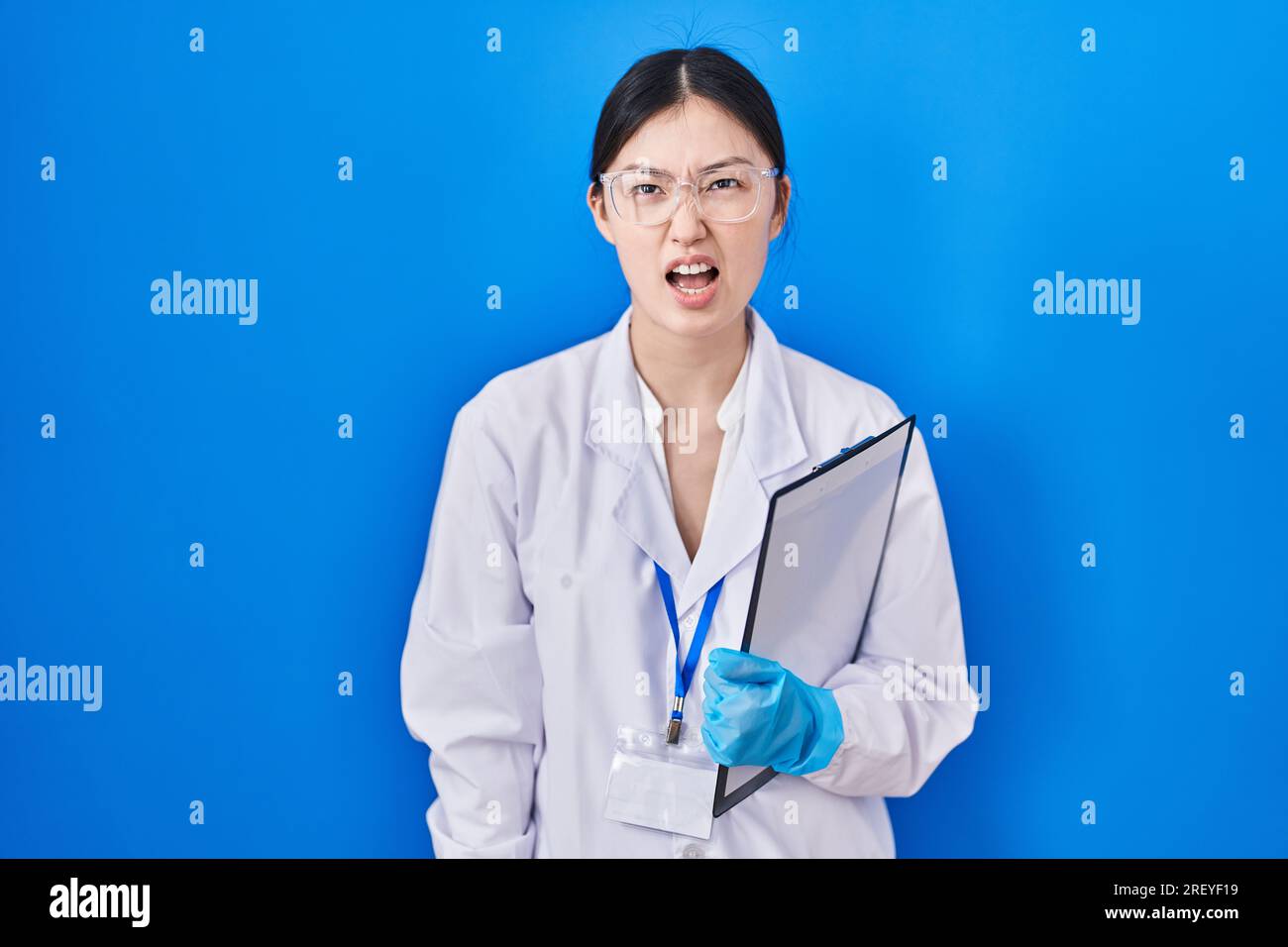Chinese young woman working at scientist laboratory angry and mad ...