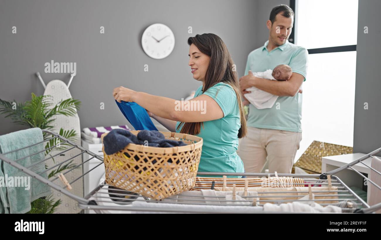 Family of three hanging clothes on clothesline at laundry room Stock ...