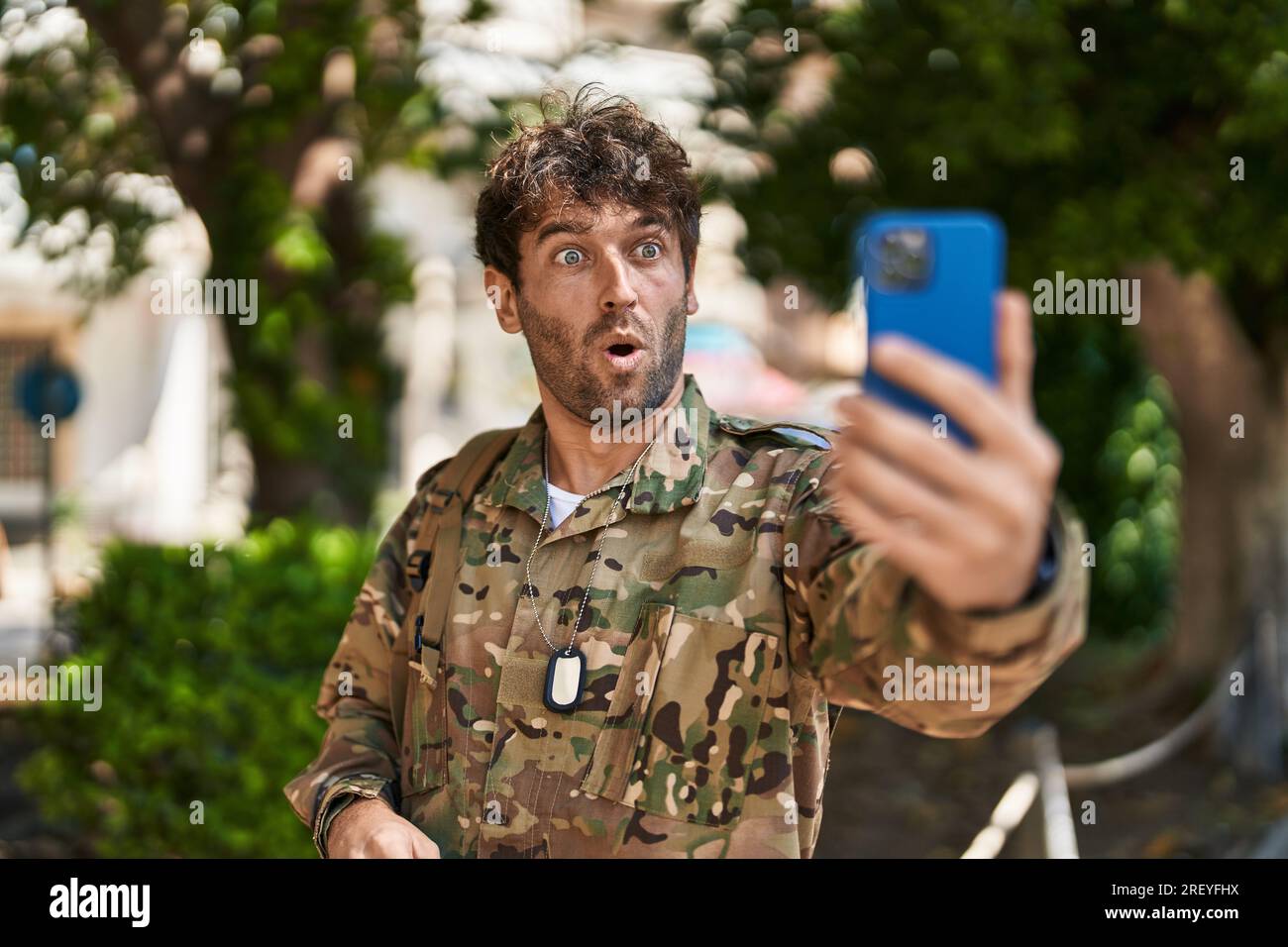 Hispanic young man wearing camouflage army uniform doing video call ...