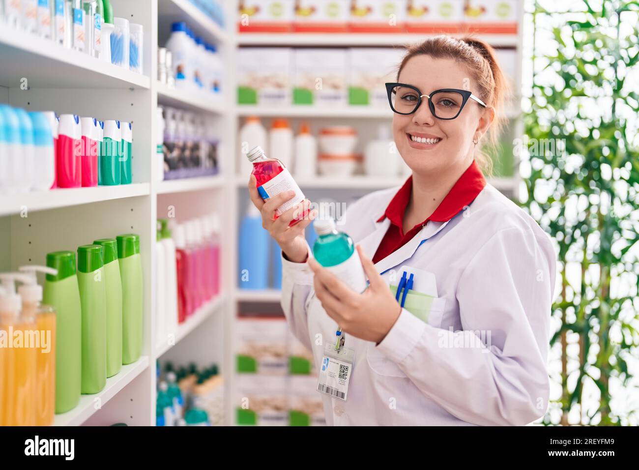 Young beautiful plus size woman pharmacist smiling confident holding ...