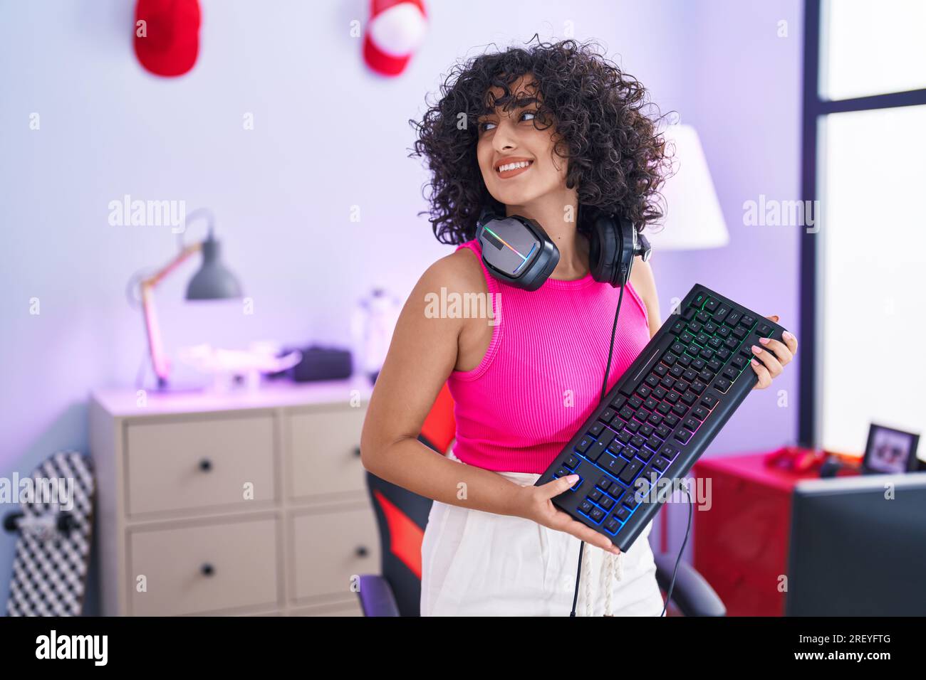 Young middle eastern woman streamer smiling confident holding keyboard ...