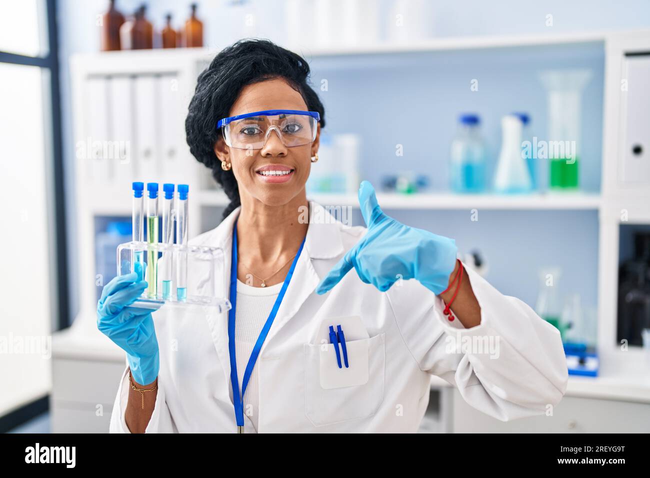 Middle age hispanic woman working at scientist laboratory pointing ...