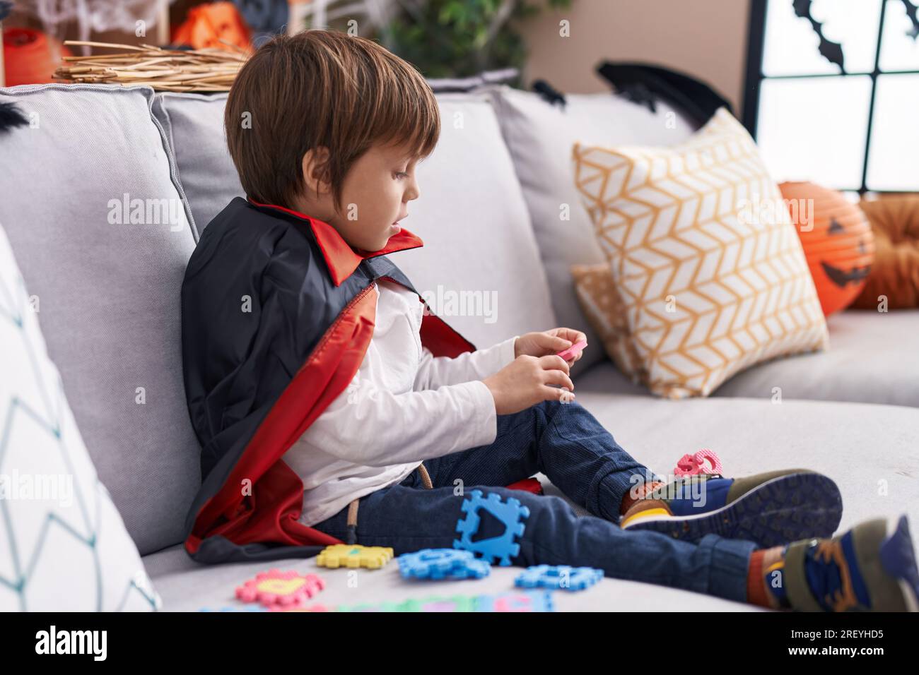Adorable caucasian boy wearing vampire costume playing with vocabulary ...