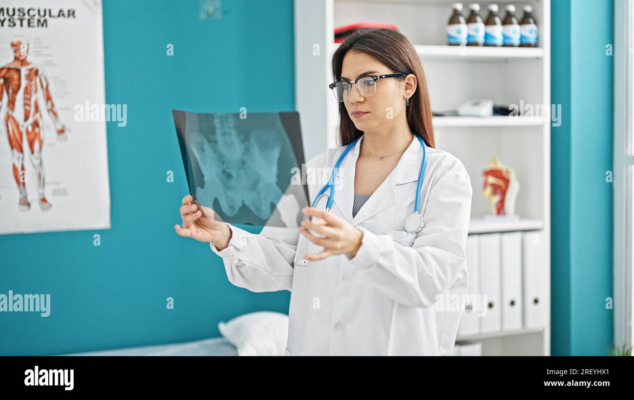 Young beautiful hispanic woman doctor looking xray at clinic Stock ...