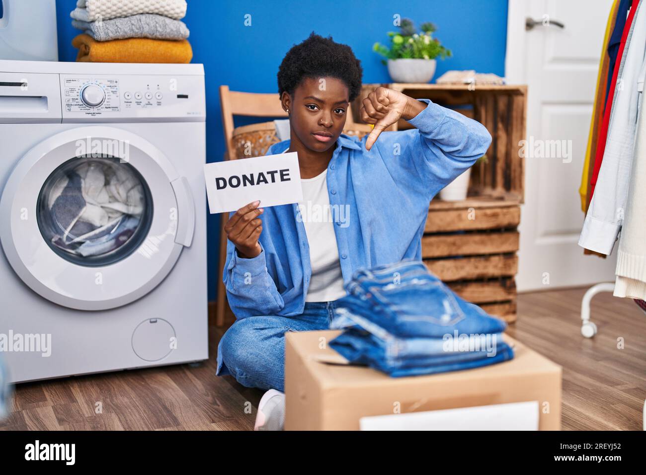 African american woman donating clothes with angry face, negative sign ...