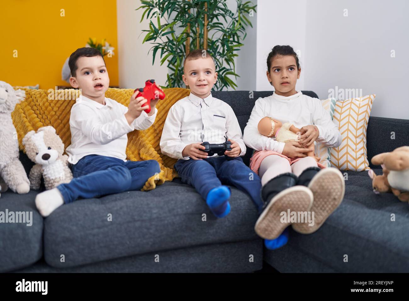 Group of kids playing video game sitting on sofa at home Stock Photo ...