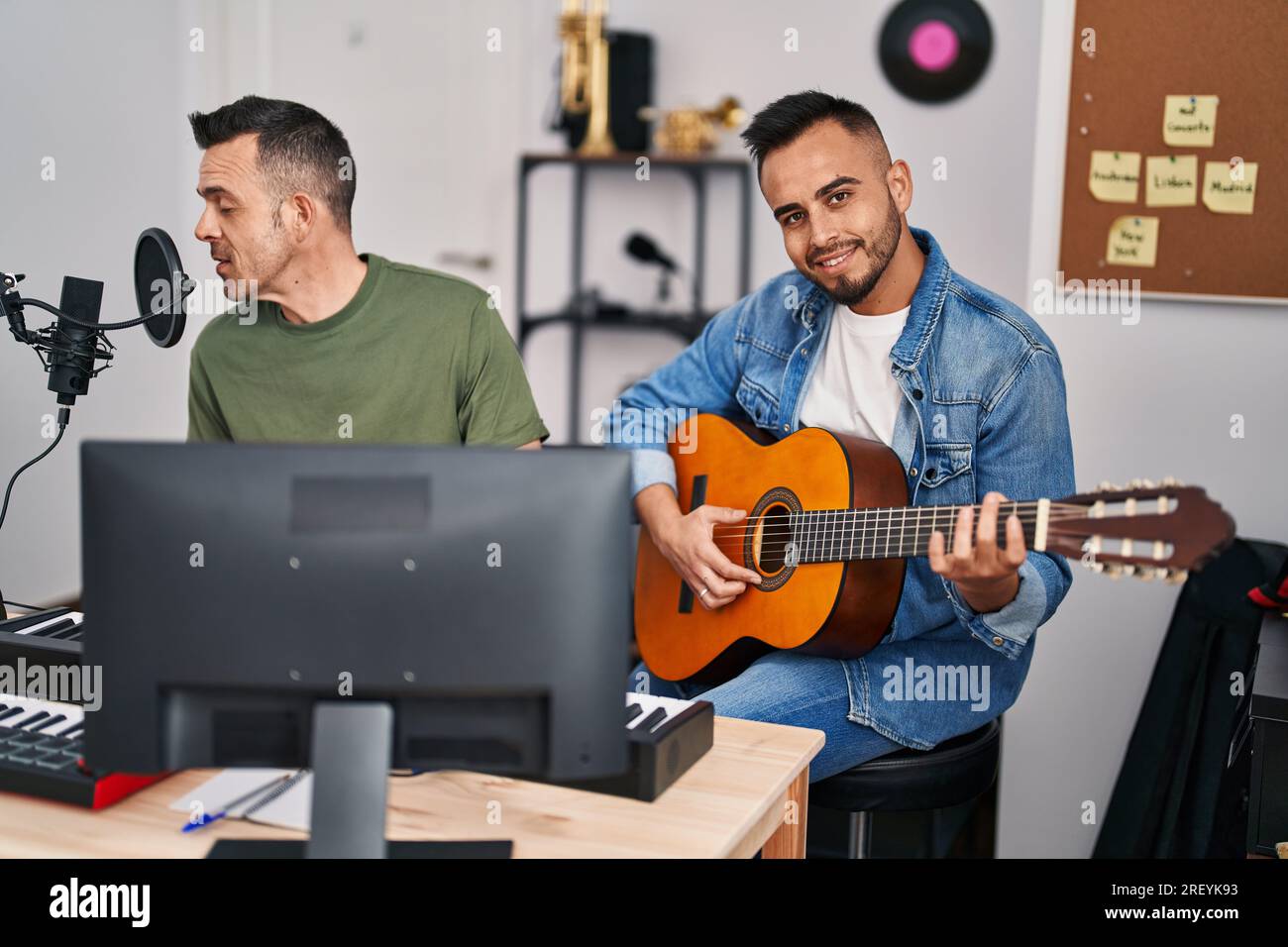 Two men musicians singing song playing piano and classical guitar at ...