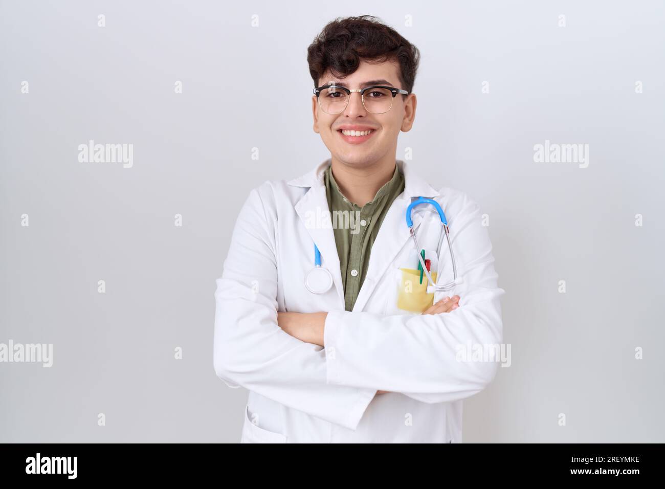 Young non binary man wearing doctor uniform and stethoscope happy face ...