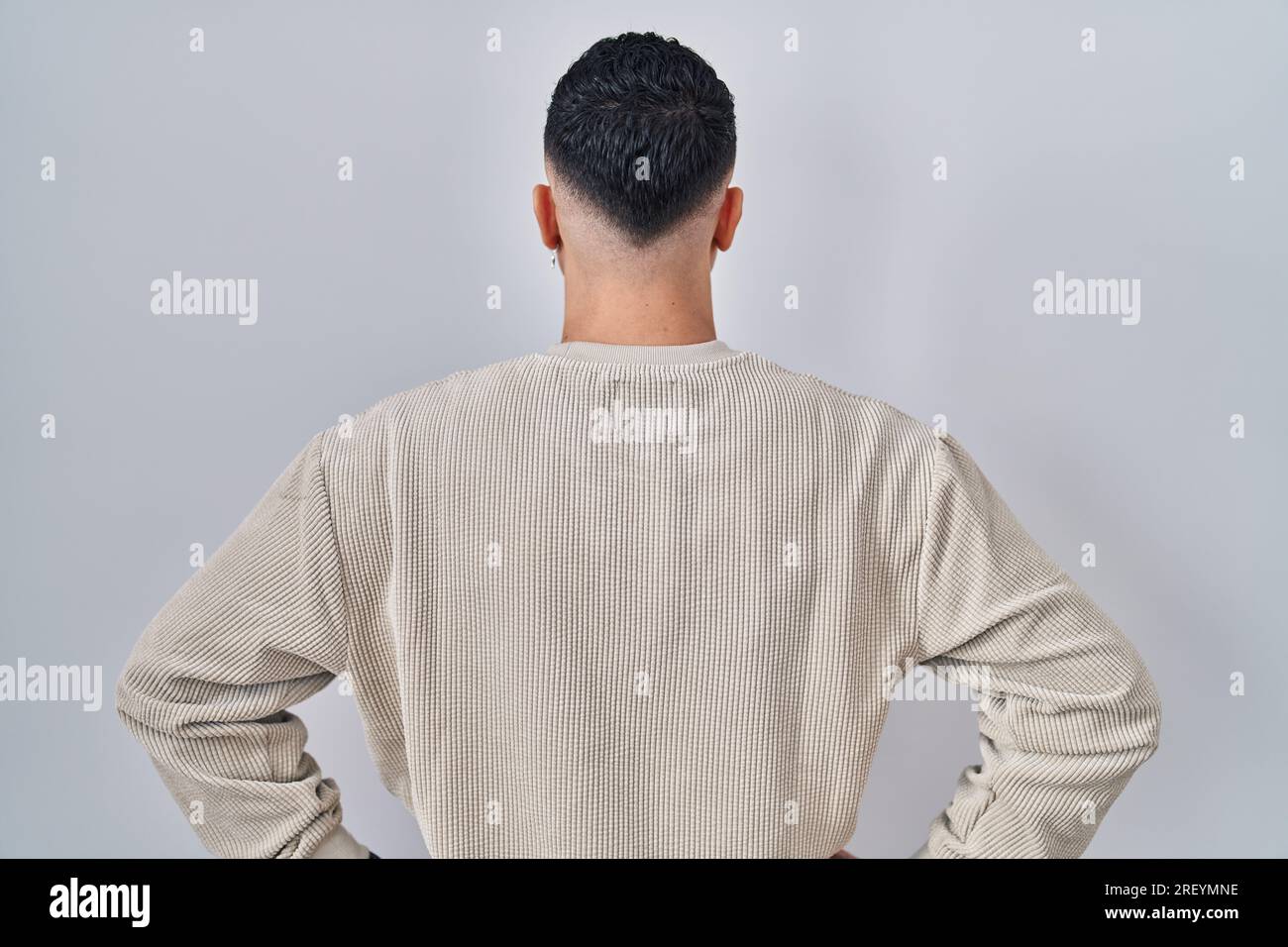 Young handsome man standing over isolated background standing backwards ...