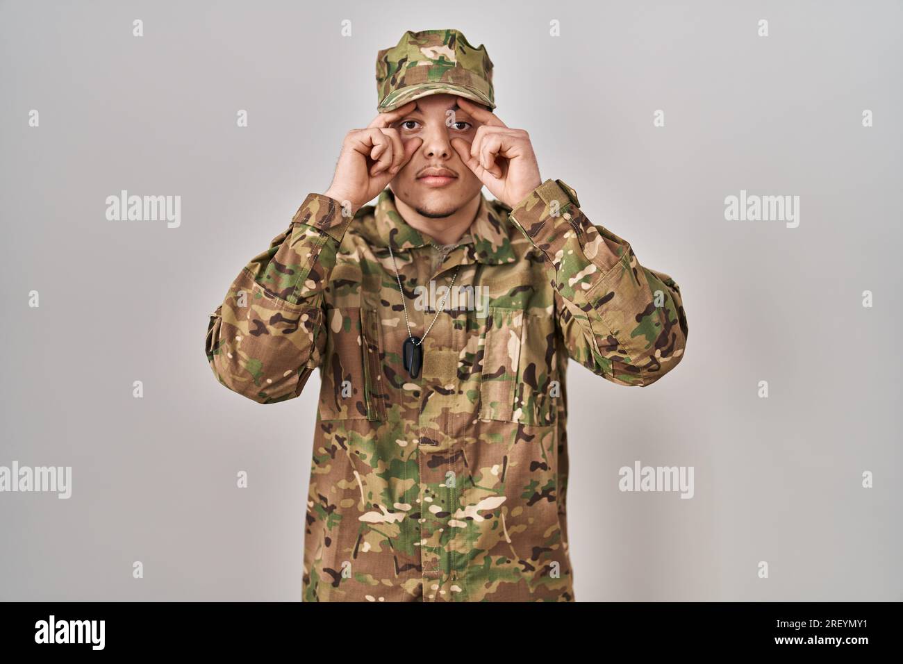 Young arab man wearing camouflage army uniform trying to open eyes with ...