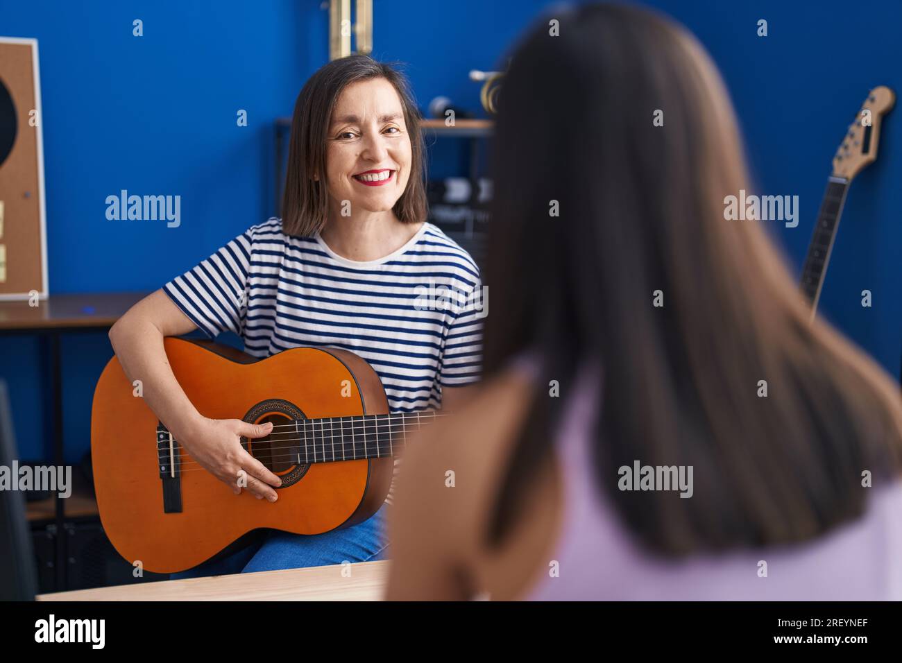 Two women musicians playing classical guitar at music studio Stock ...