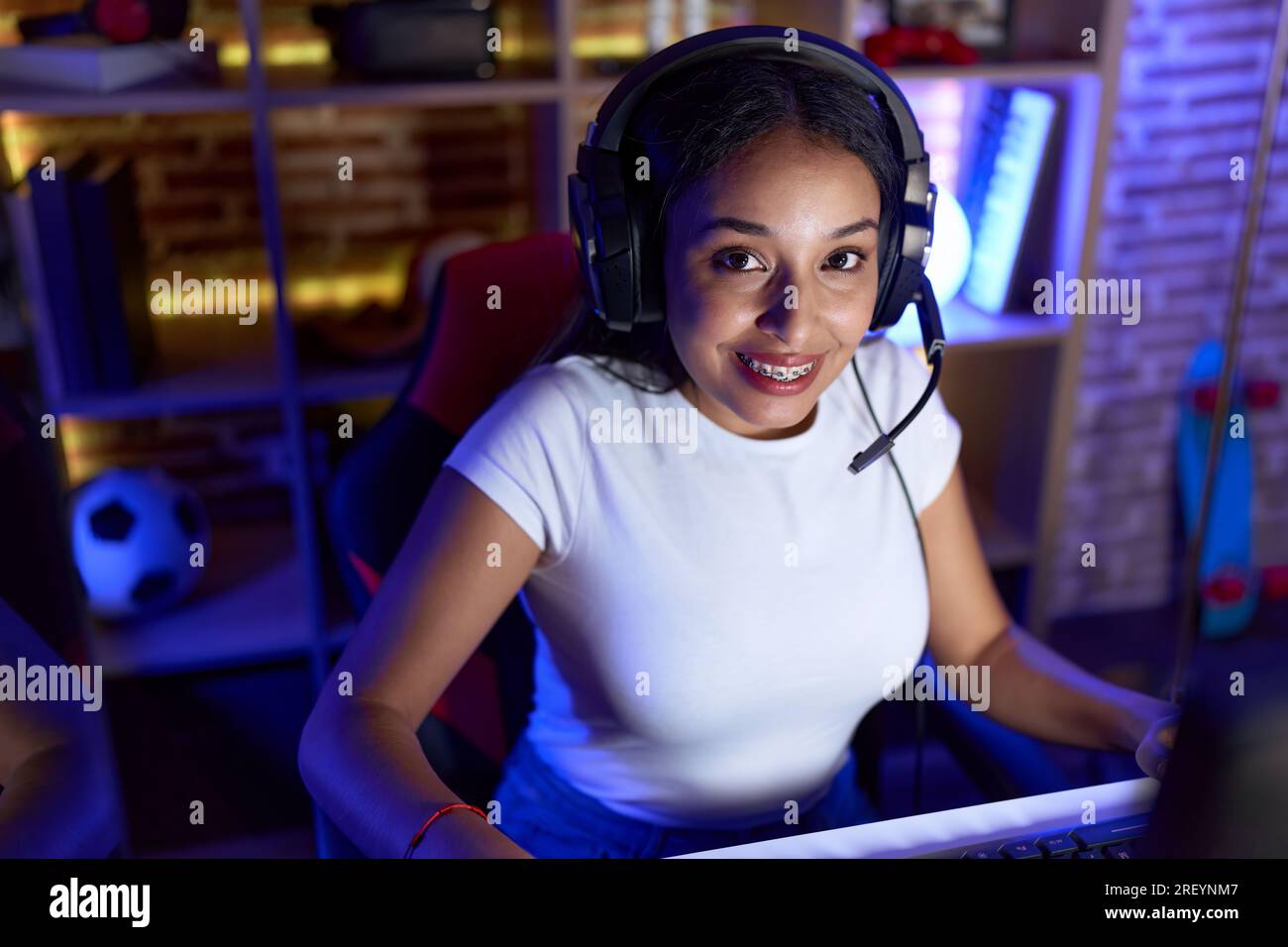 Young arab woman streamer playing video game using computer at gaming ...