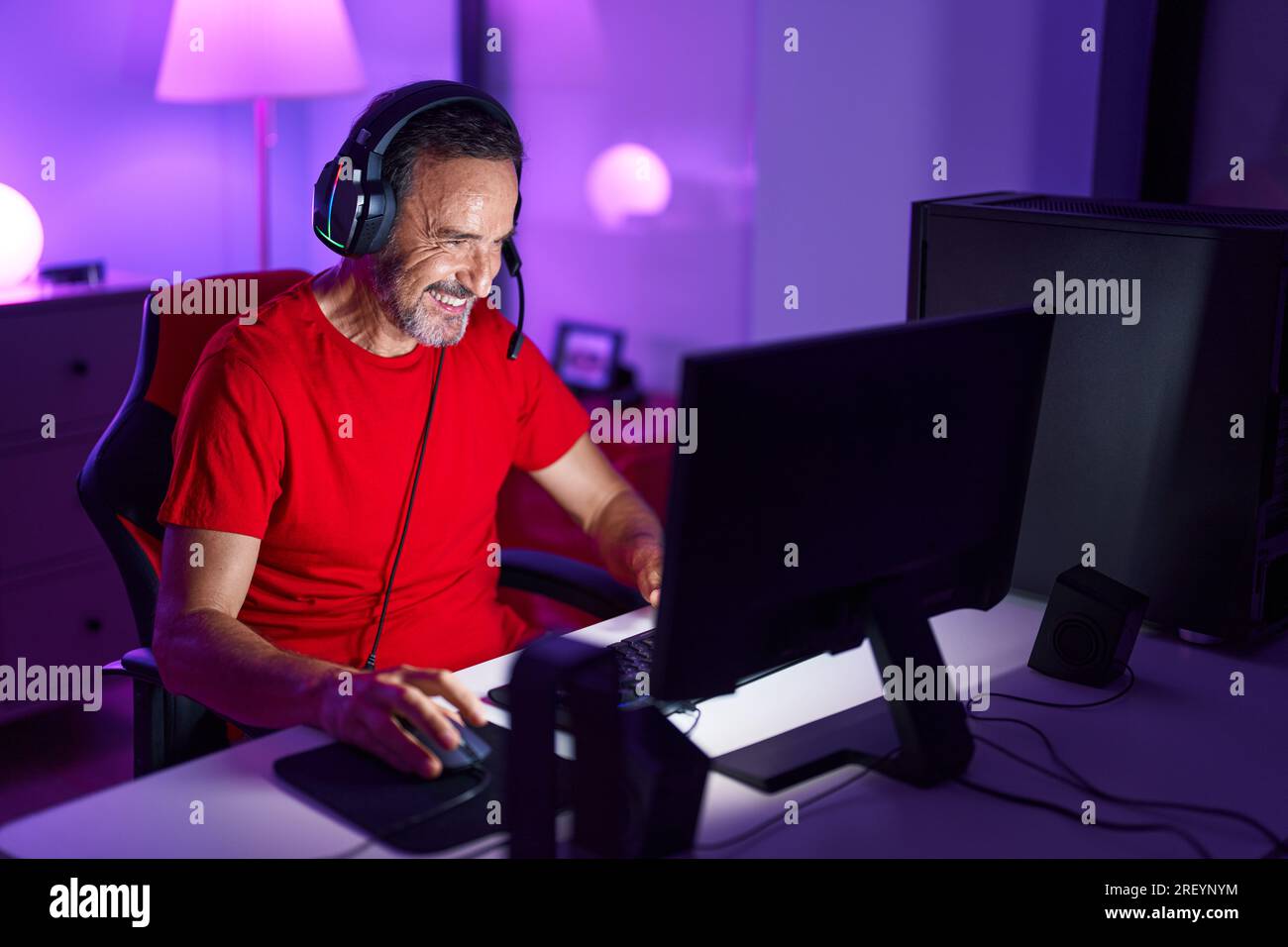 Middle age man streamer playing video game using computer at gaming ...