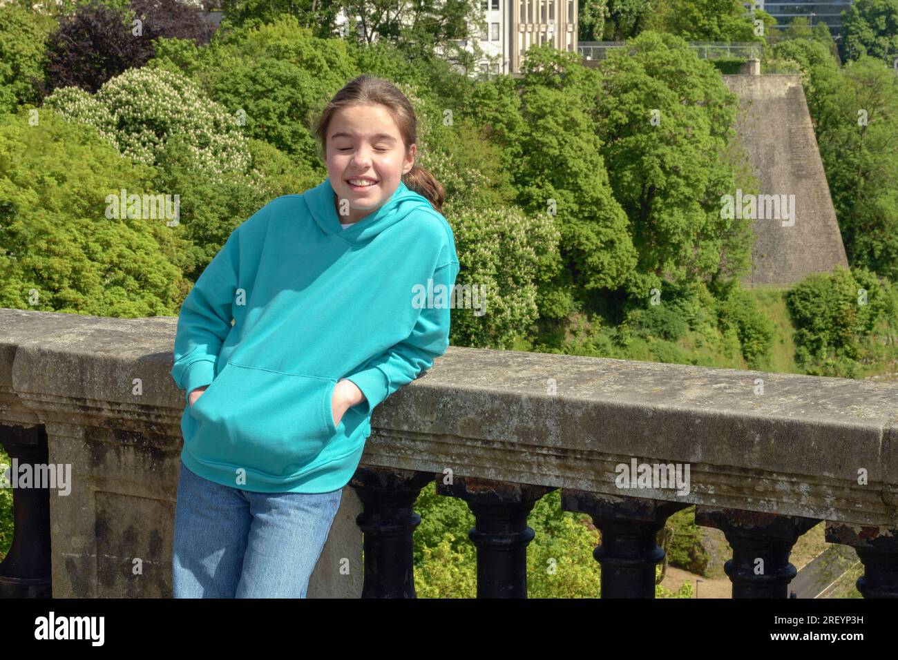 The sun is too bright for the photo. The girl squints in the bright sun ...