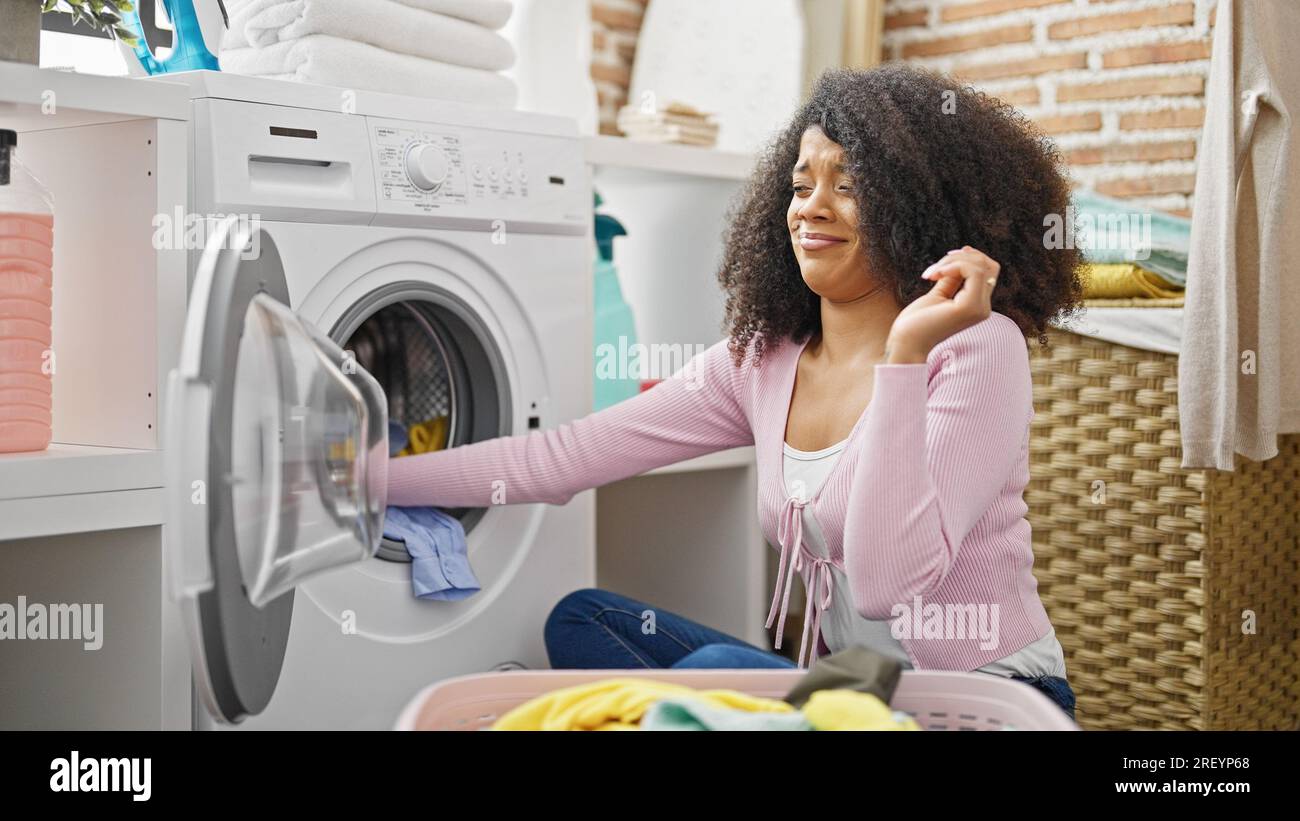 African american woman washing clothes at laundry room Stock Photo - Alamy