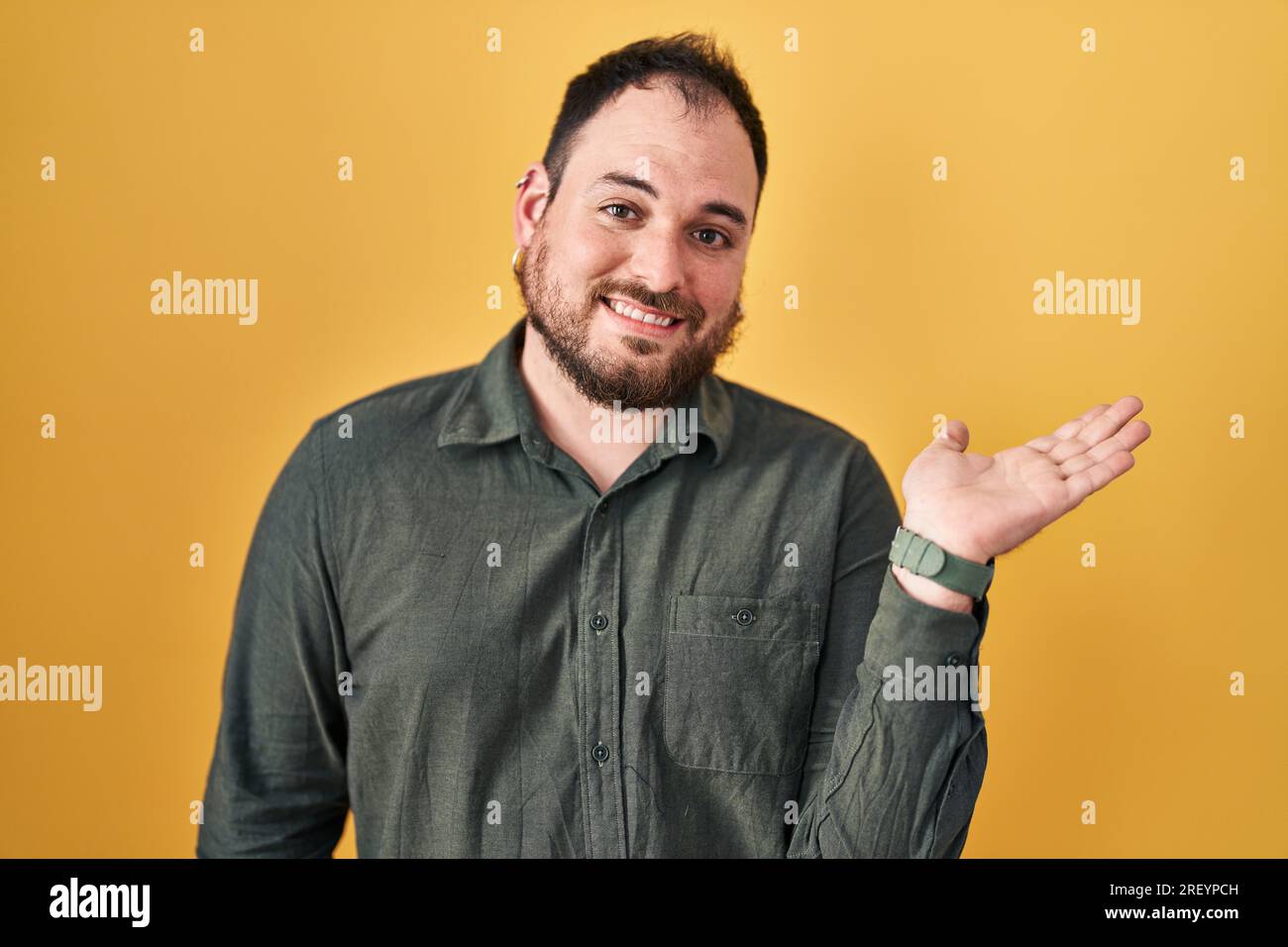 Plus size hispanic man with beard standing over yellow background ...