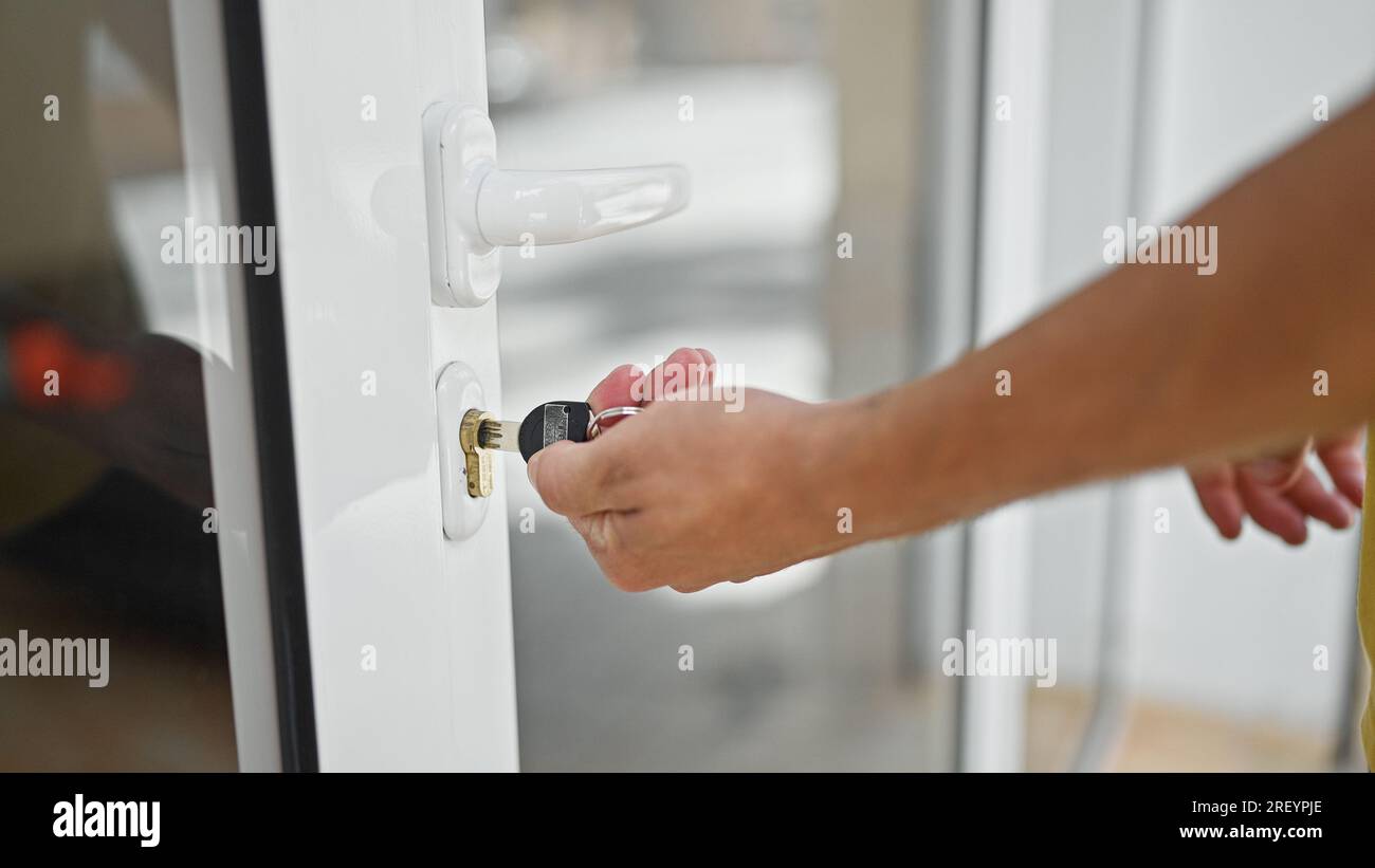 Young hispanic man closing door using key at home Stock Photo - Alamy