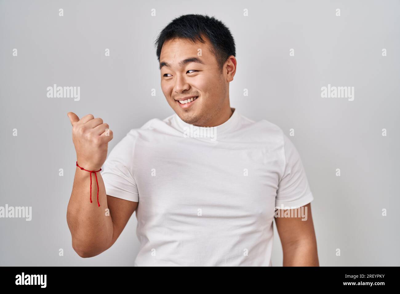 Young chinese man standing over white background smiling with happy ...