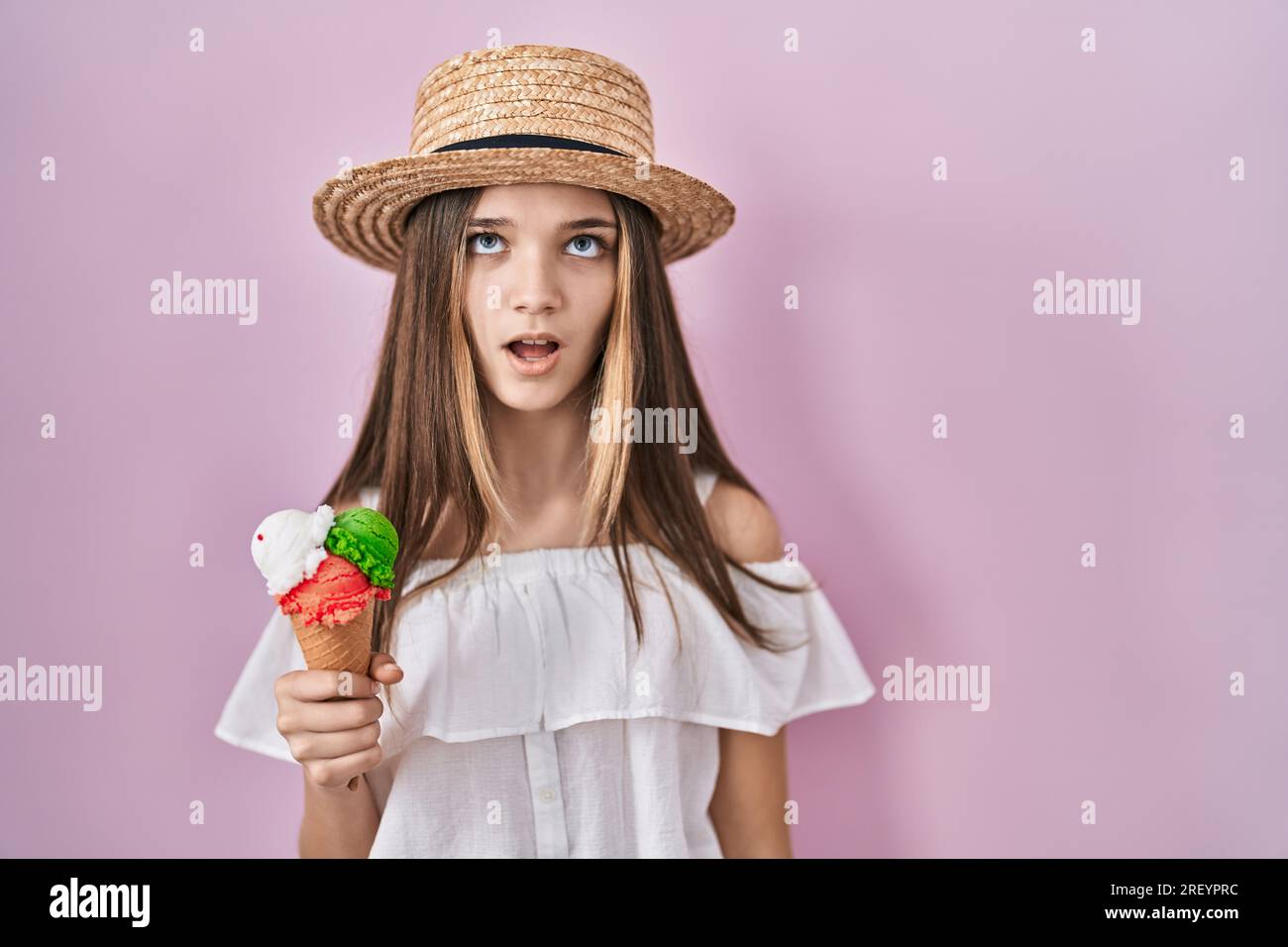 Teenager girl holding ice cream angry and mad screaming frustrated and ...
