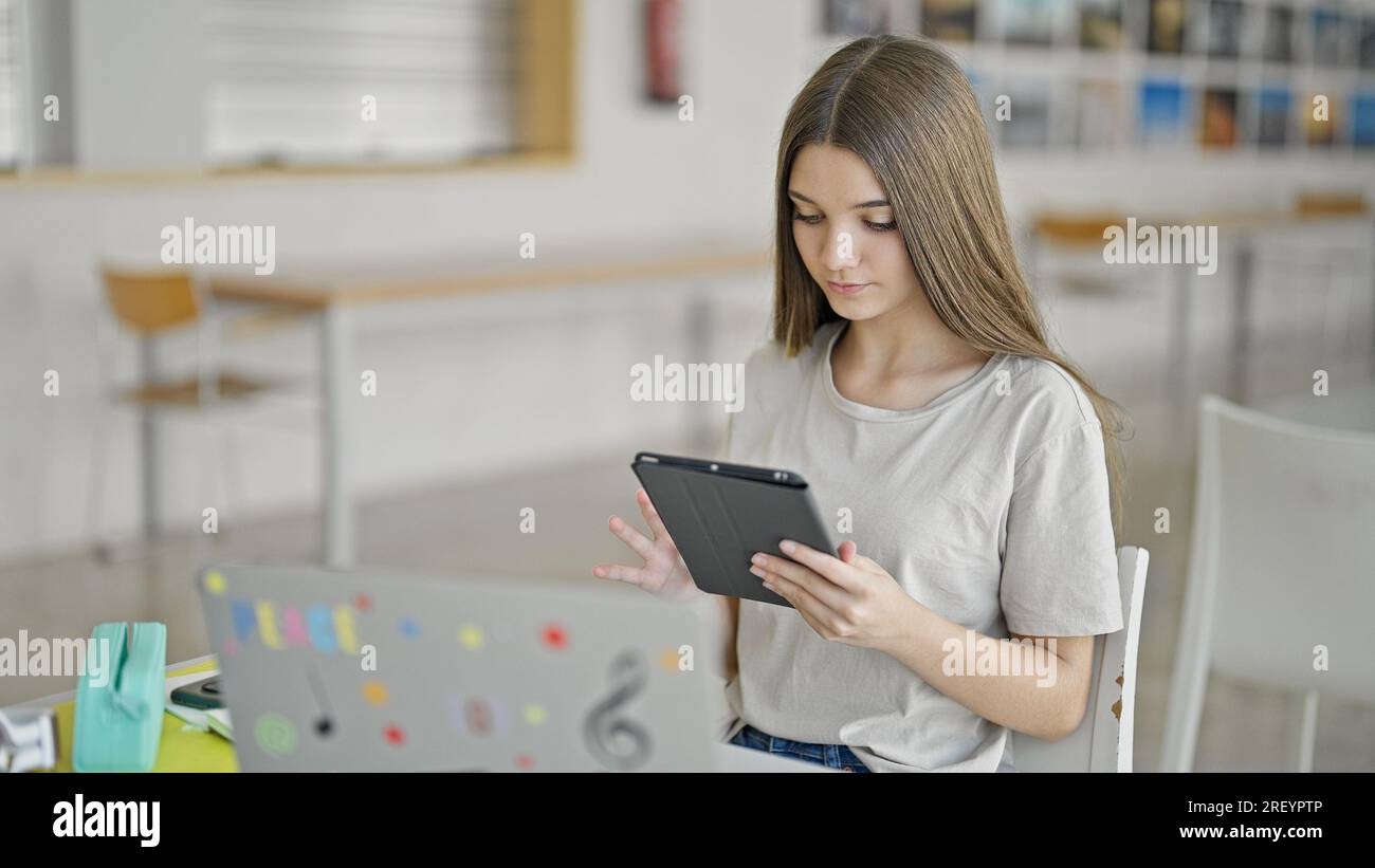 Young beautiful girl student using laptop and touchpad studying at ...