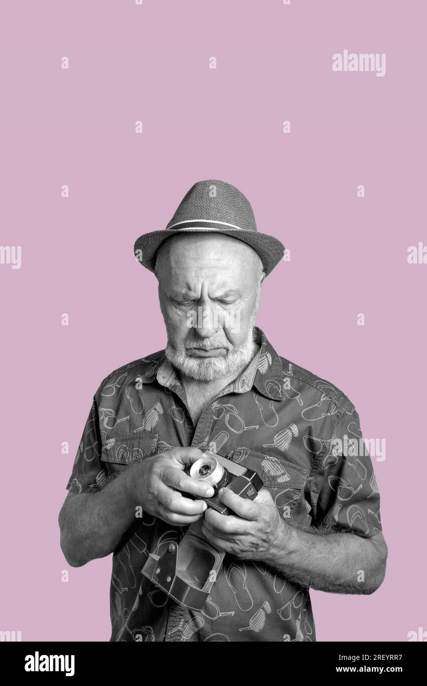 Elderly man with a film camera. The old man tries to remember the ...