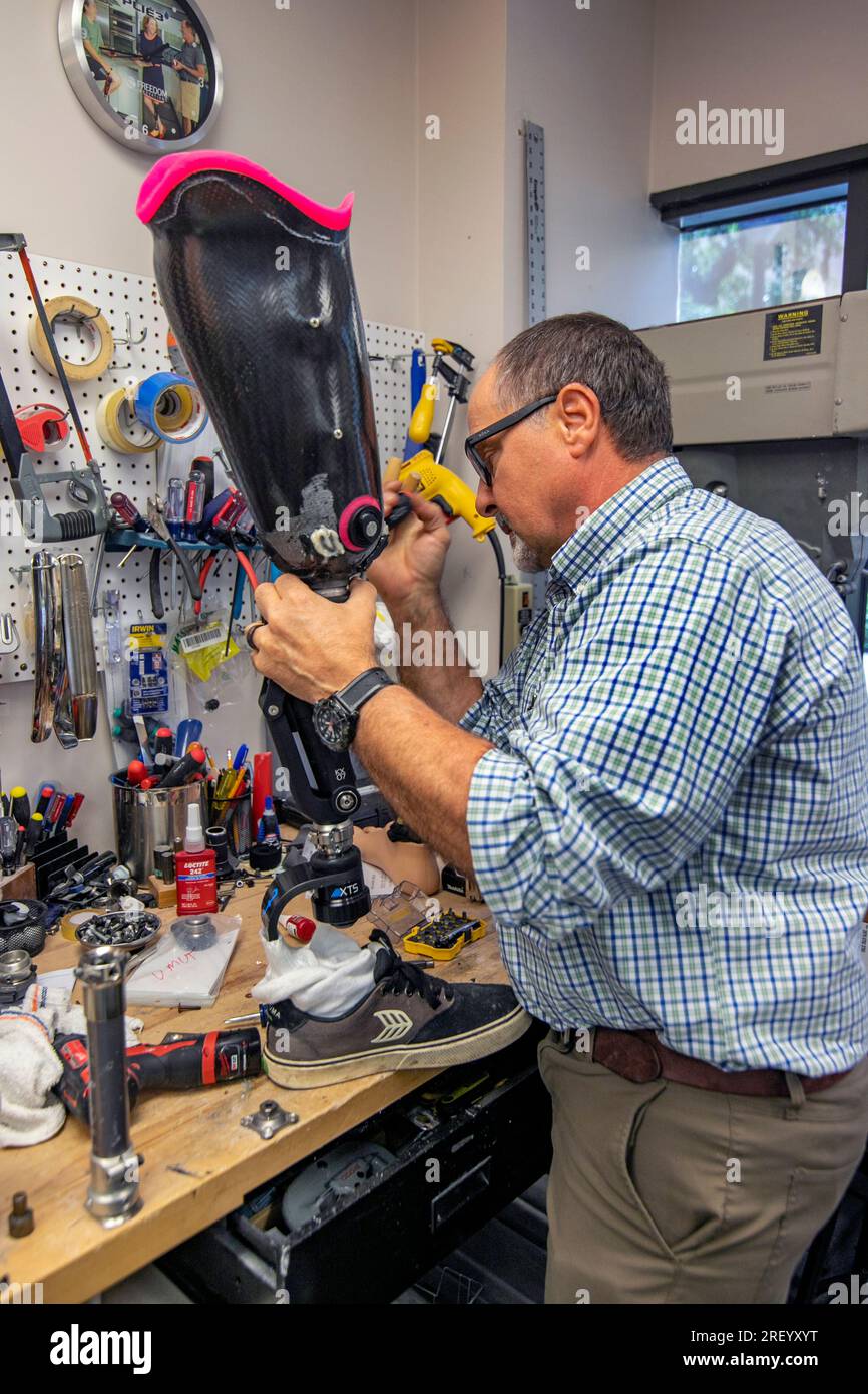 A technician works on a a prosthetic leg in the workshop of a ...