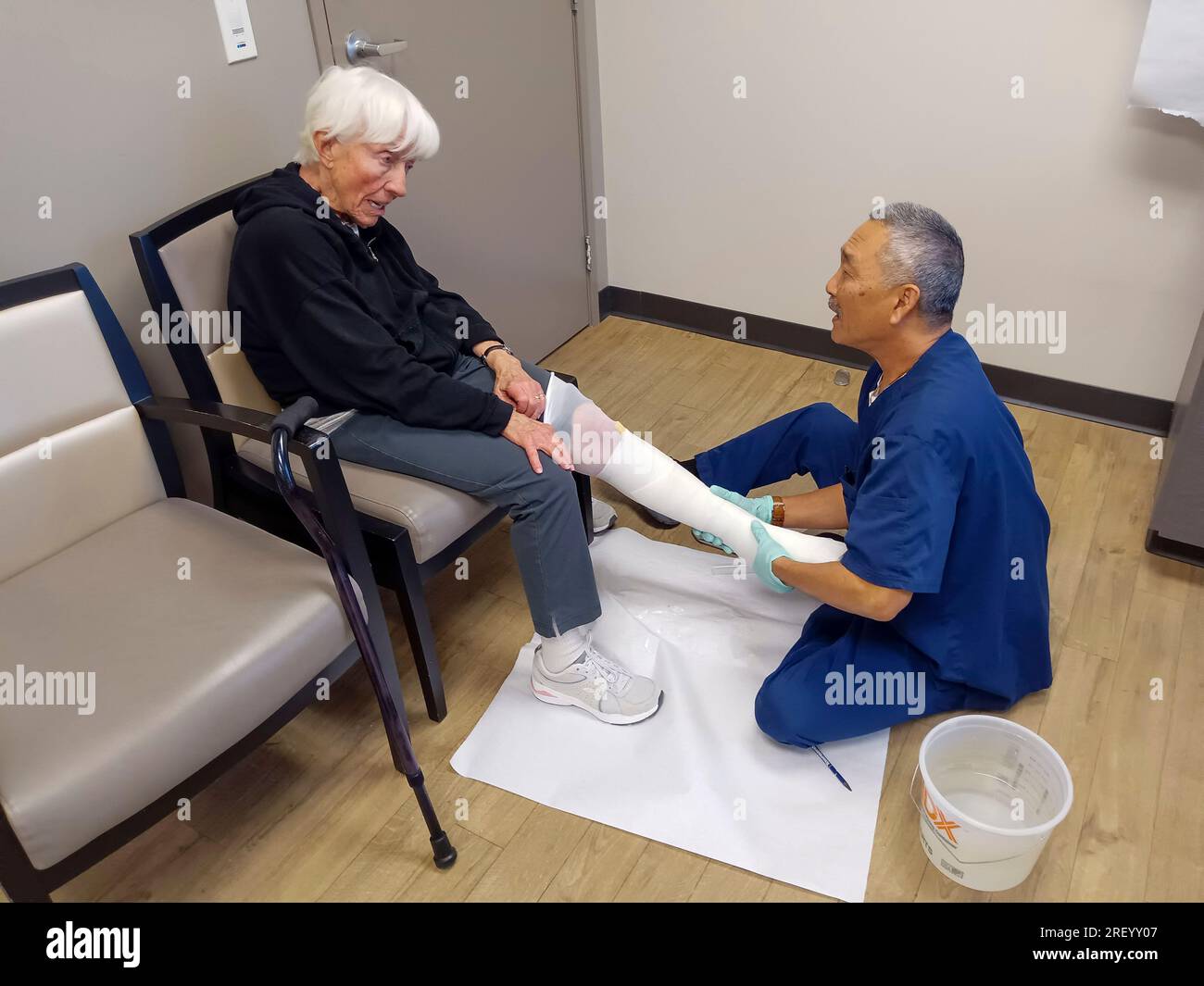 A Japanese-American prosthetic technician makes a cast of the leg of a ...