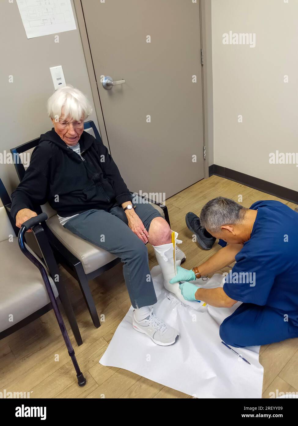 A Japanese-American prosthetic technician makes a cast of the leg of a ...