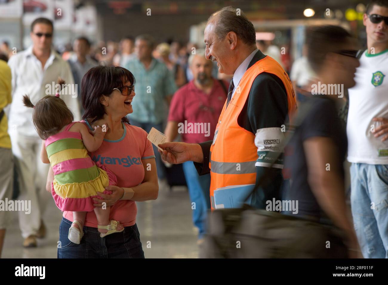Trenitalia platform staff helping passengers at Milan's busy mainline ...