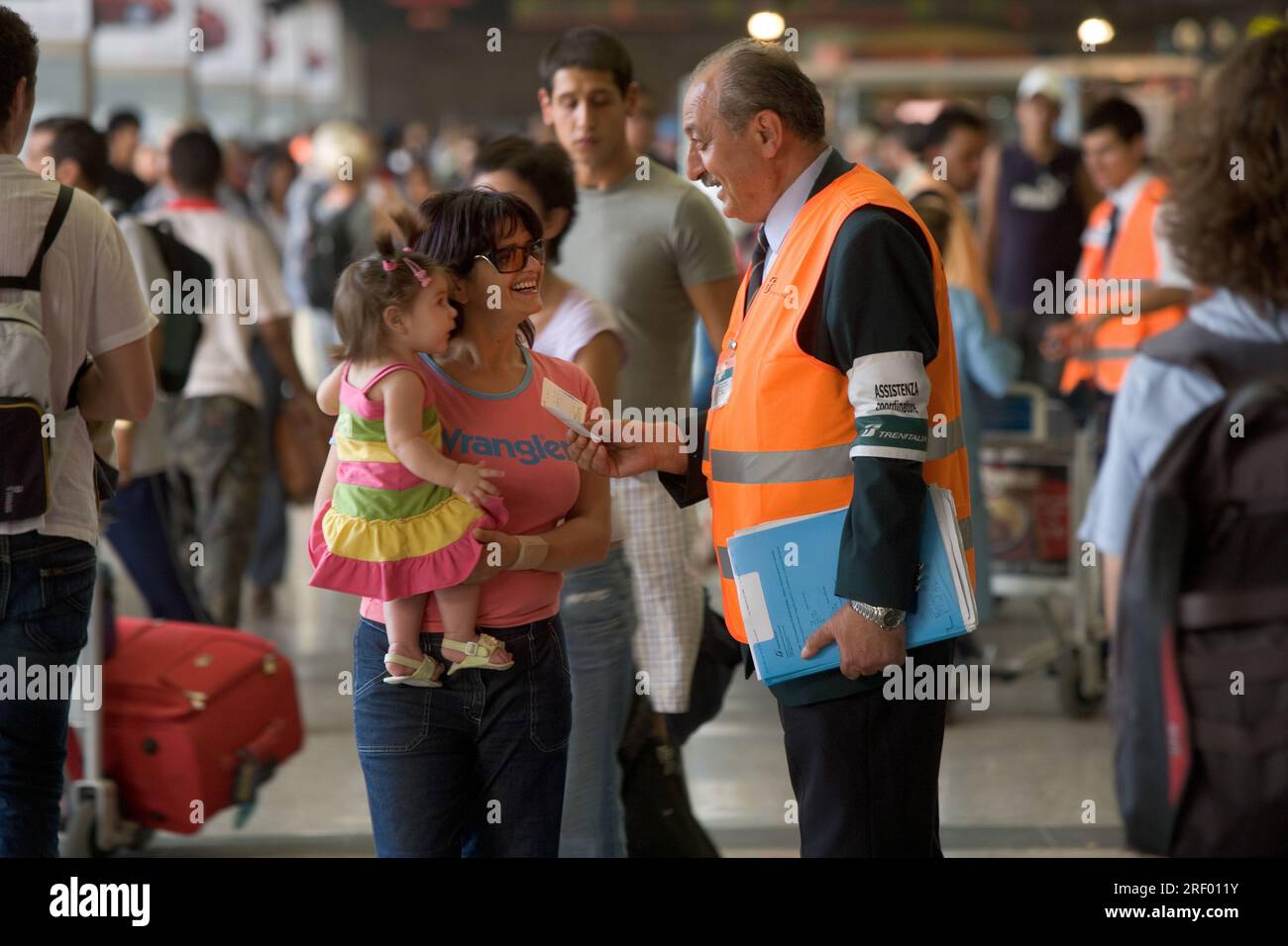 Trenitalia platform staff helping passengers at Milan's busy mainline ...