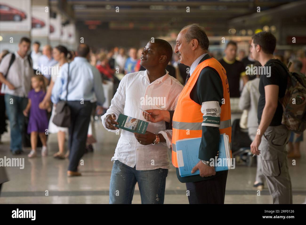 Trenitalia platform staff helping passengers at Milan's busy mainline ...