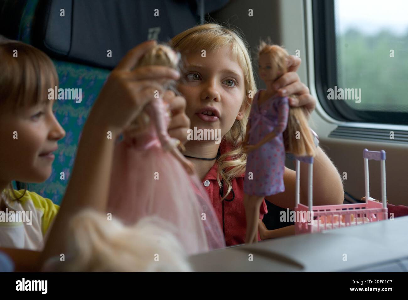 Children playing with dolls on a train, engaging in imaginative play ...