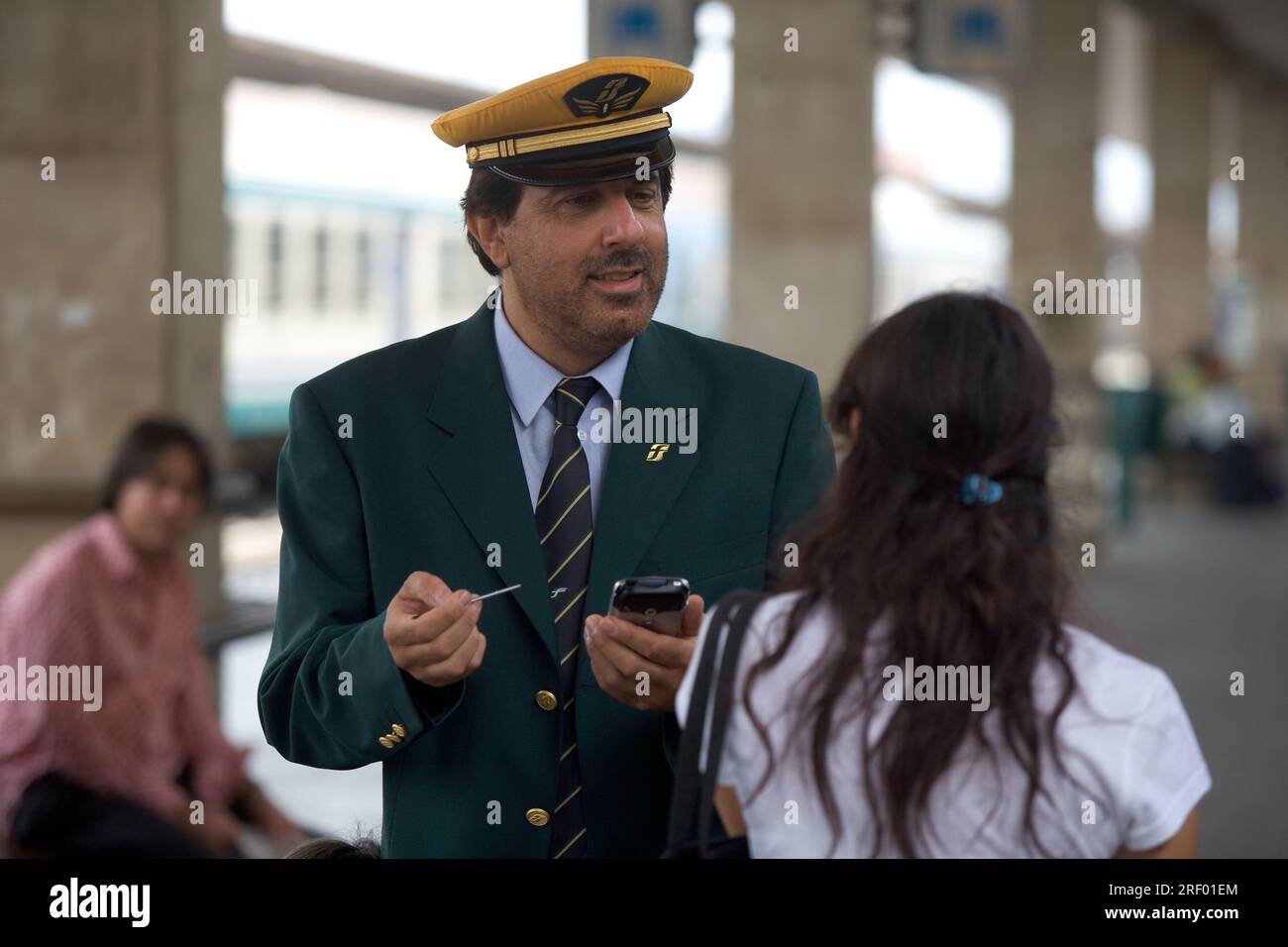 Trenitalia platform staff helping passengers at Milan's busy mainline ...