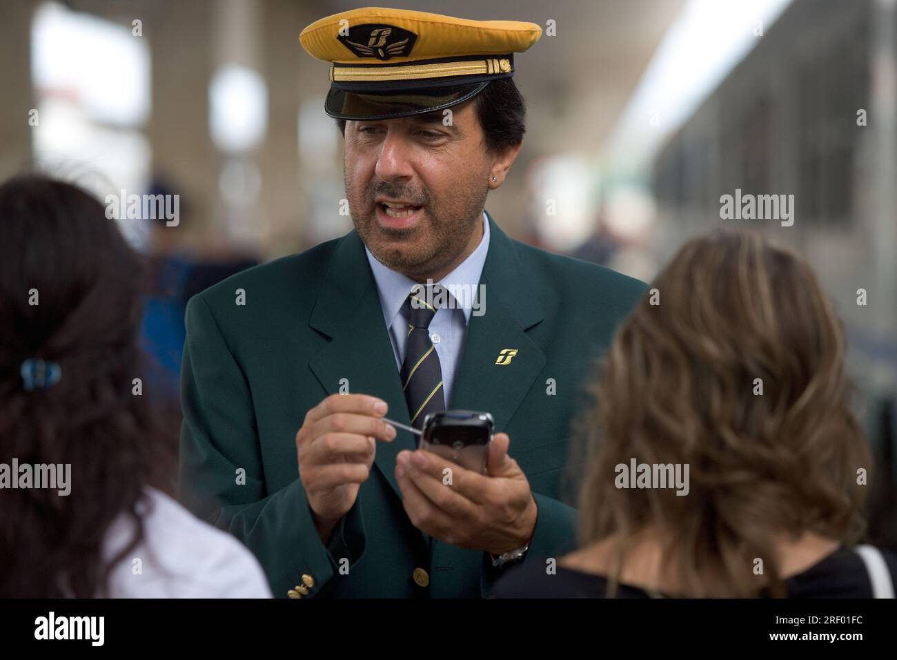 Trenitalia platform staff helping passengers at Milan's busy mainline ...
