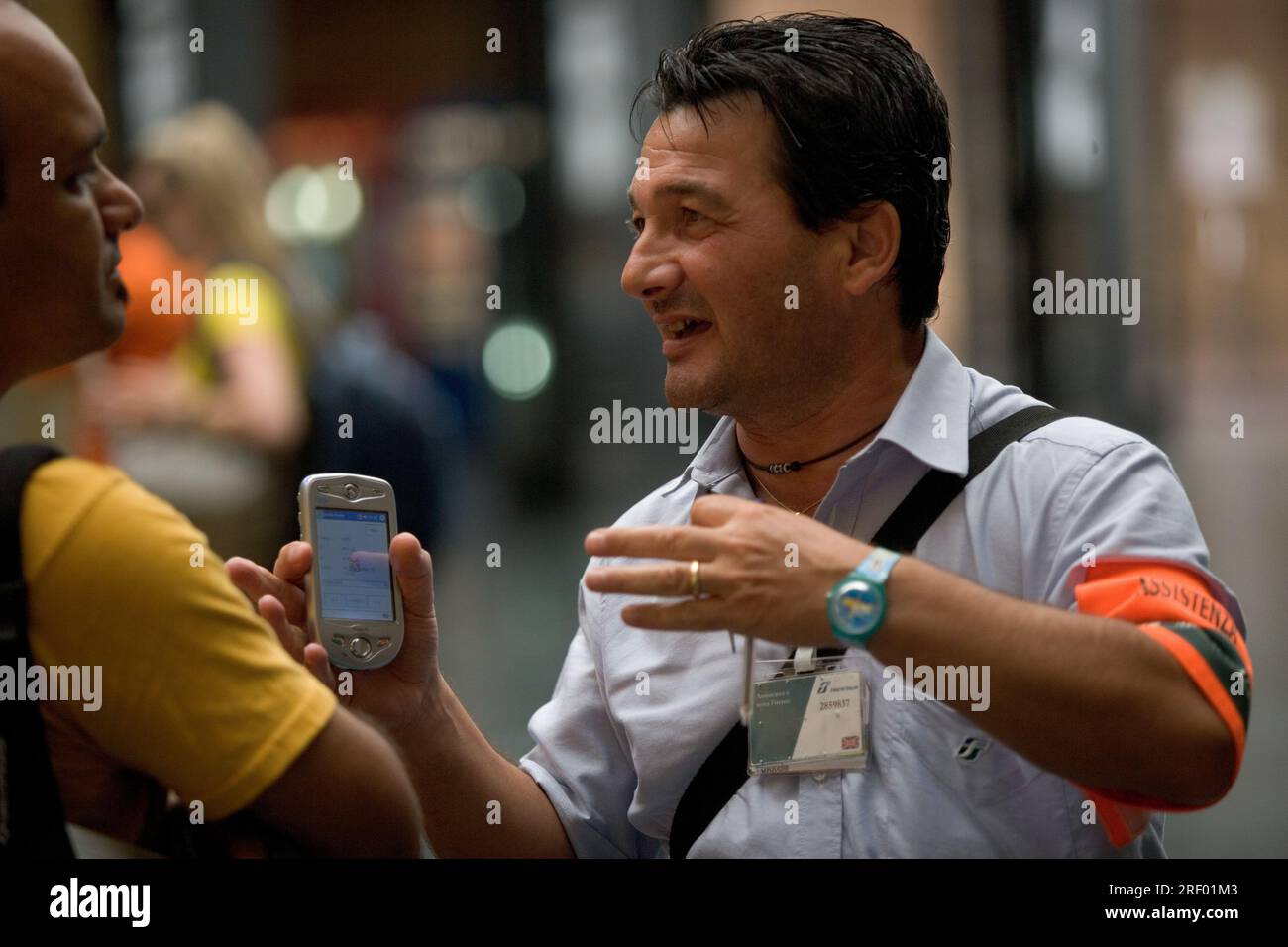 Trenitalia platform staff helping passengers at Milan's busy mainline ...