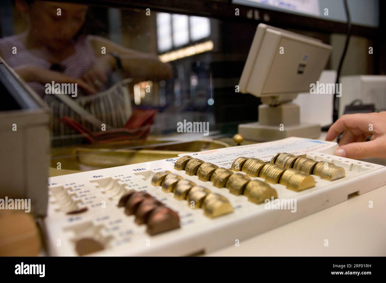 A currency exchange counter with coins and a person accessing their ...