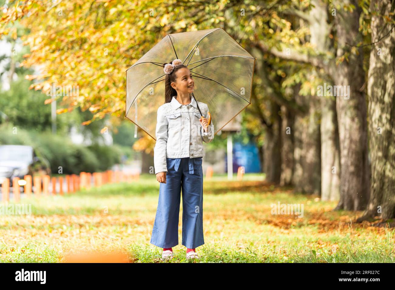 Kid playing out in the rain. Children with umbrella play outdoors in ...
