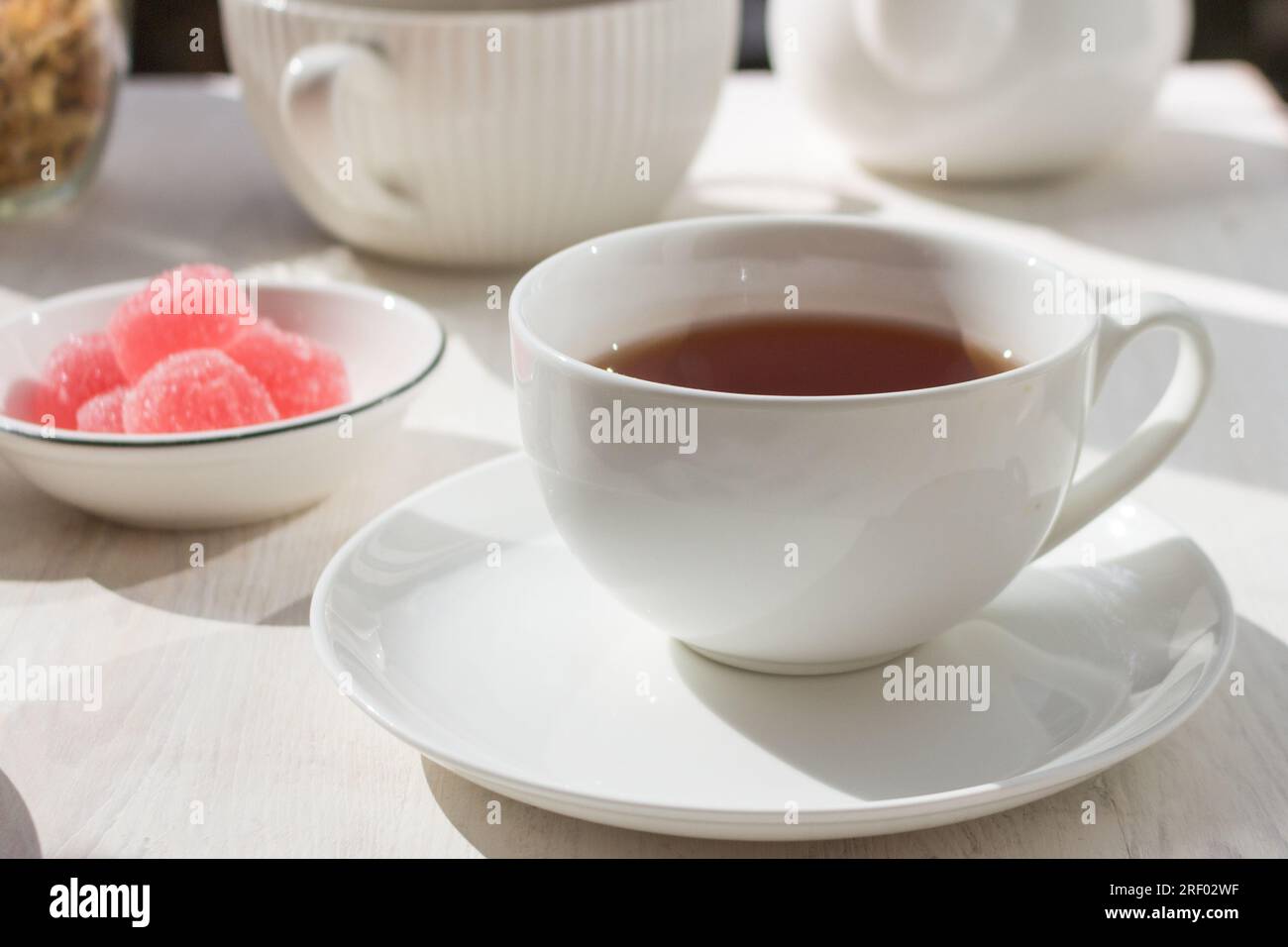 a cup of black tea fruit marmalade on a white wooden table. Morning tea ...