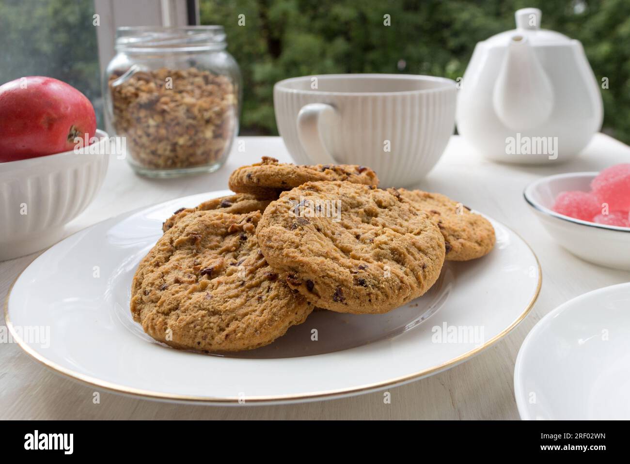 Healthy breakfast. Muesli, cup of tea, honey, cookies, apple and banana ...