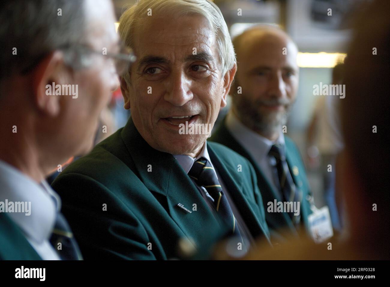 A group of men in formal attire, engaged in conversation at a ...