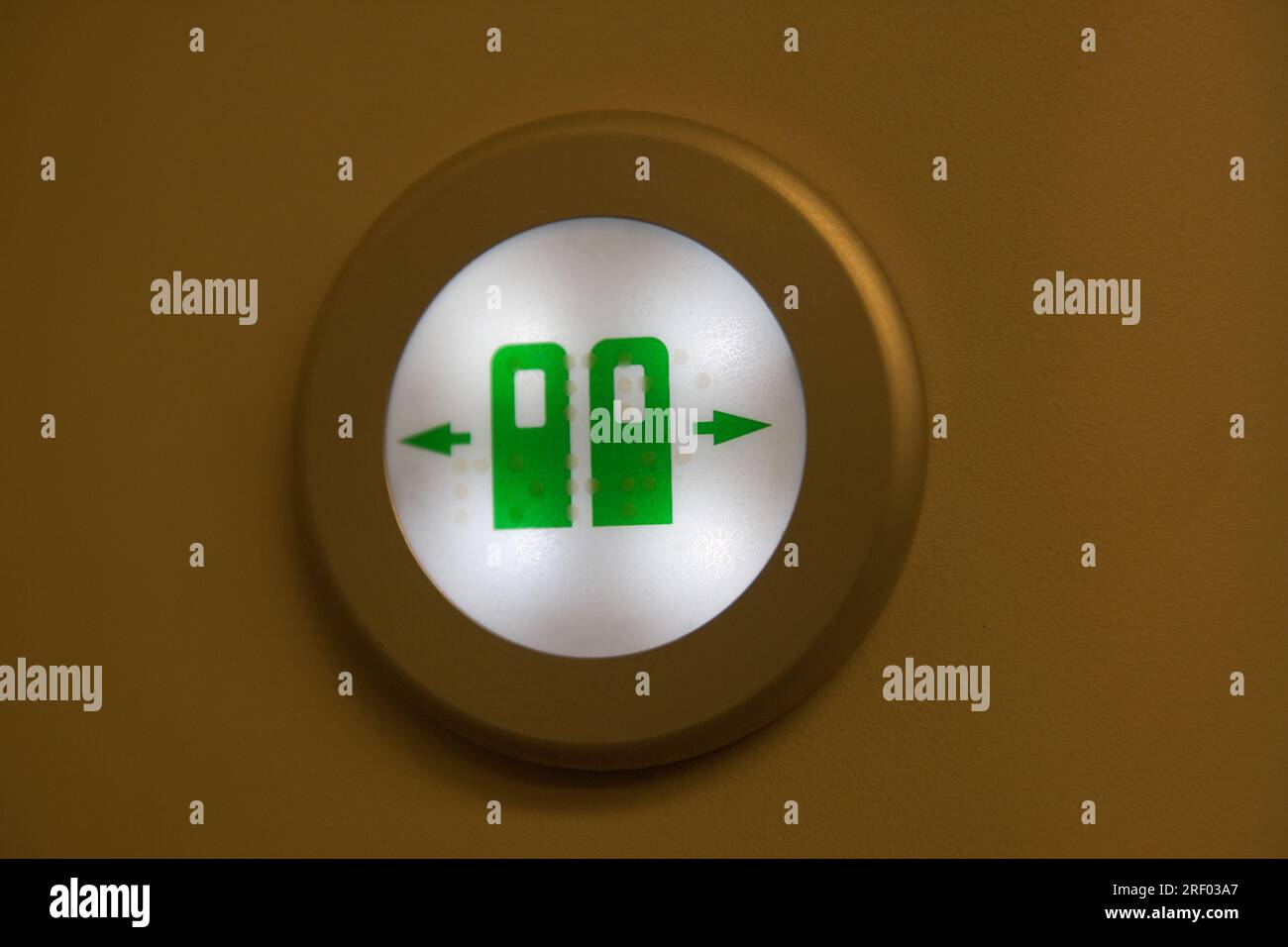 Circular sign indicating automatic sliding doors with green arrows ...