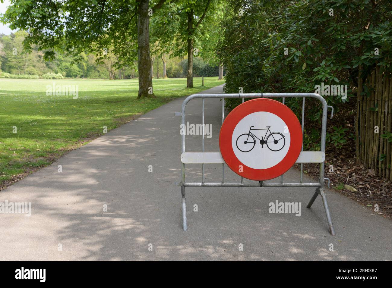 Portable fencing in a park with a warning sign - bicycle access ...