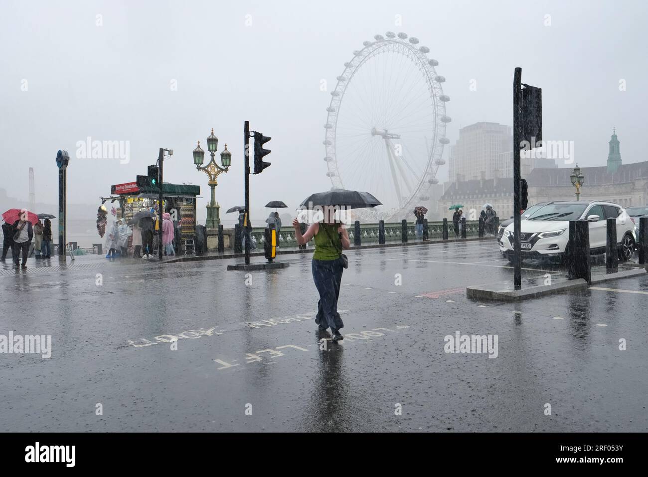 London, UK. 30th July, 2023. A heavy rain shower in Westminster causes ...