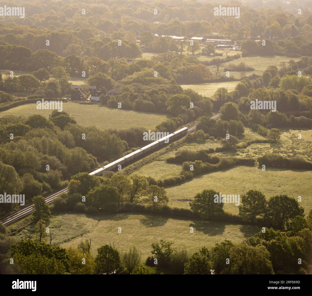 Aerial view of a train on a railway line in the countryside in Kent, UK ...
