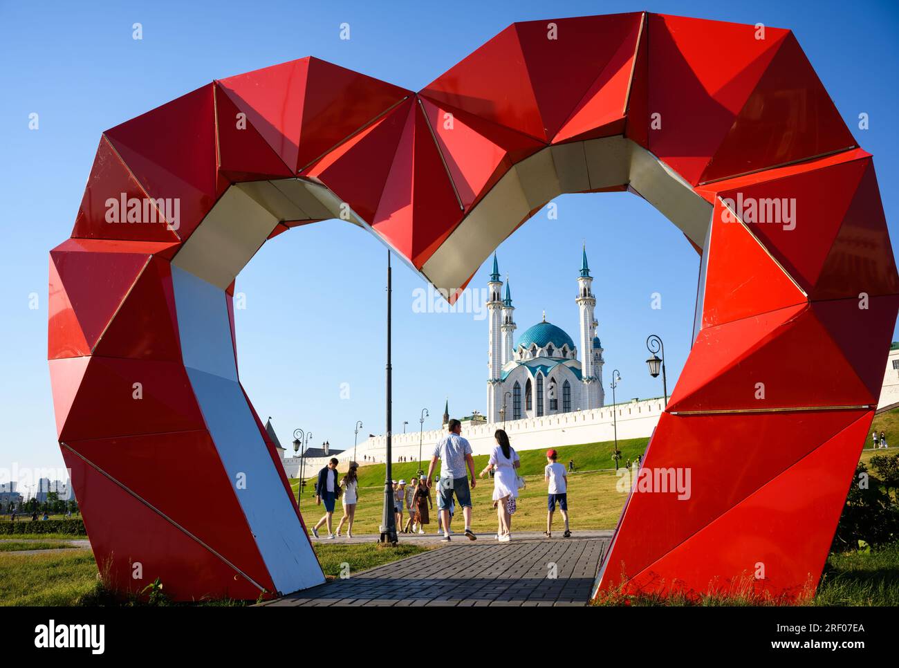 People walk near heart shaped city decoration near Kazan Kremlin in ...