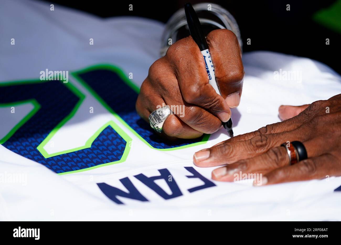 Former Seattle Seahawks tight end Ron Howard signs a jersey for a fan ...
