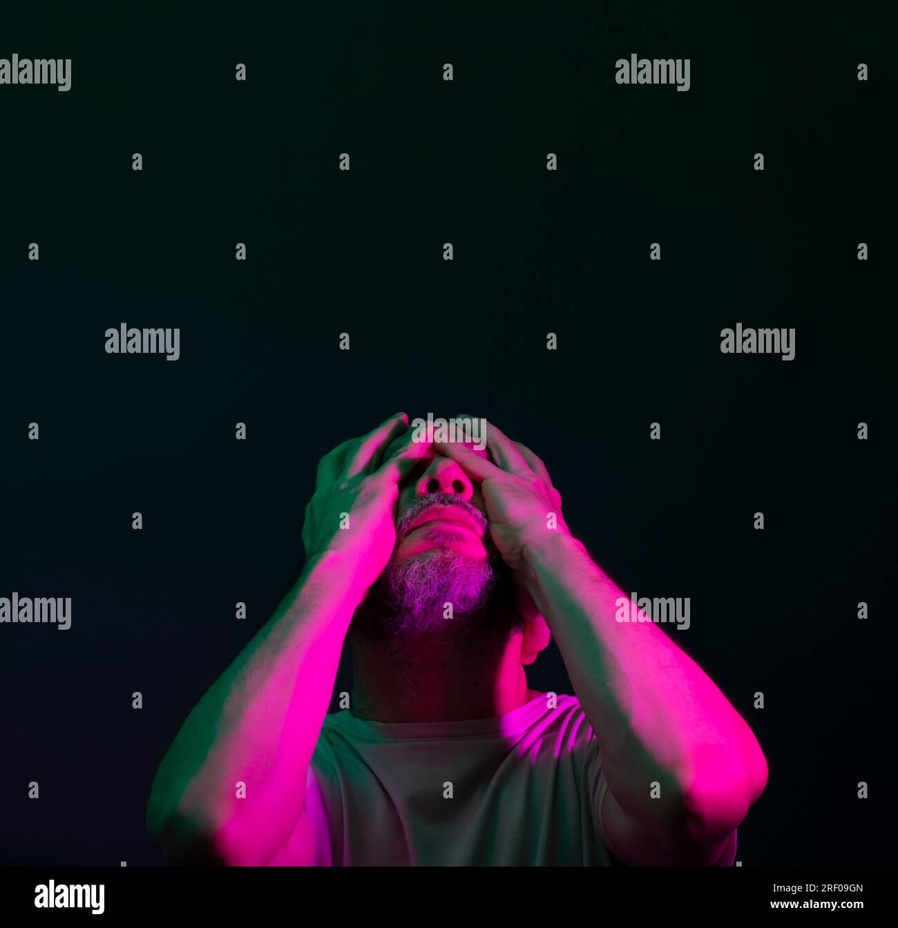 Man in his 50s, emotionally shaken showing stress or pain gesture ...