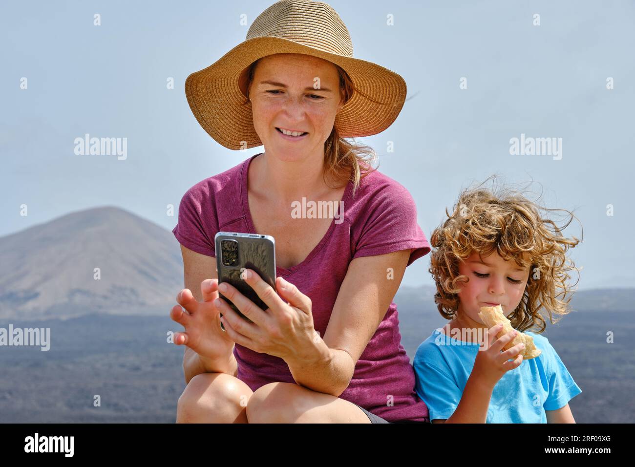 Mother with son using phone in nature Stock Photo - Alamy