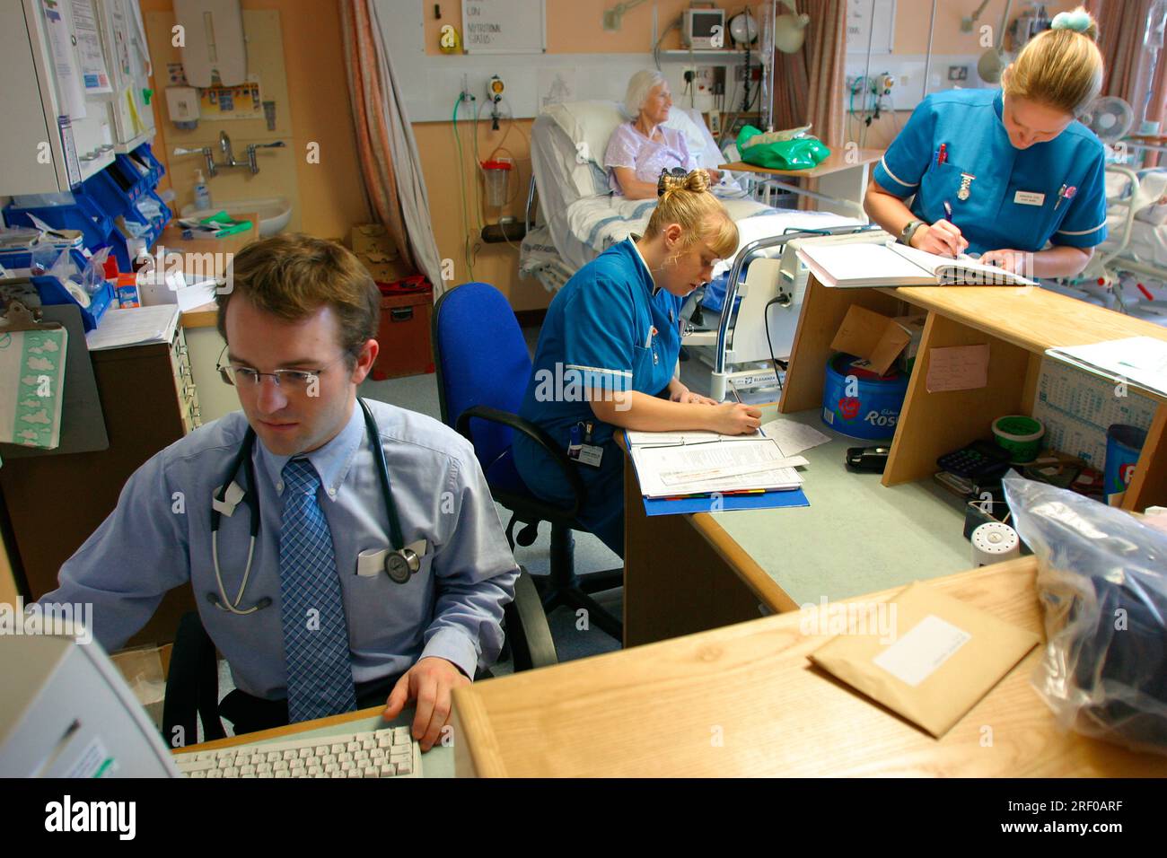A doctor and nurses doing admin at a ward nursing station. nursing ...