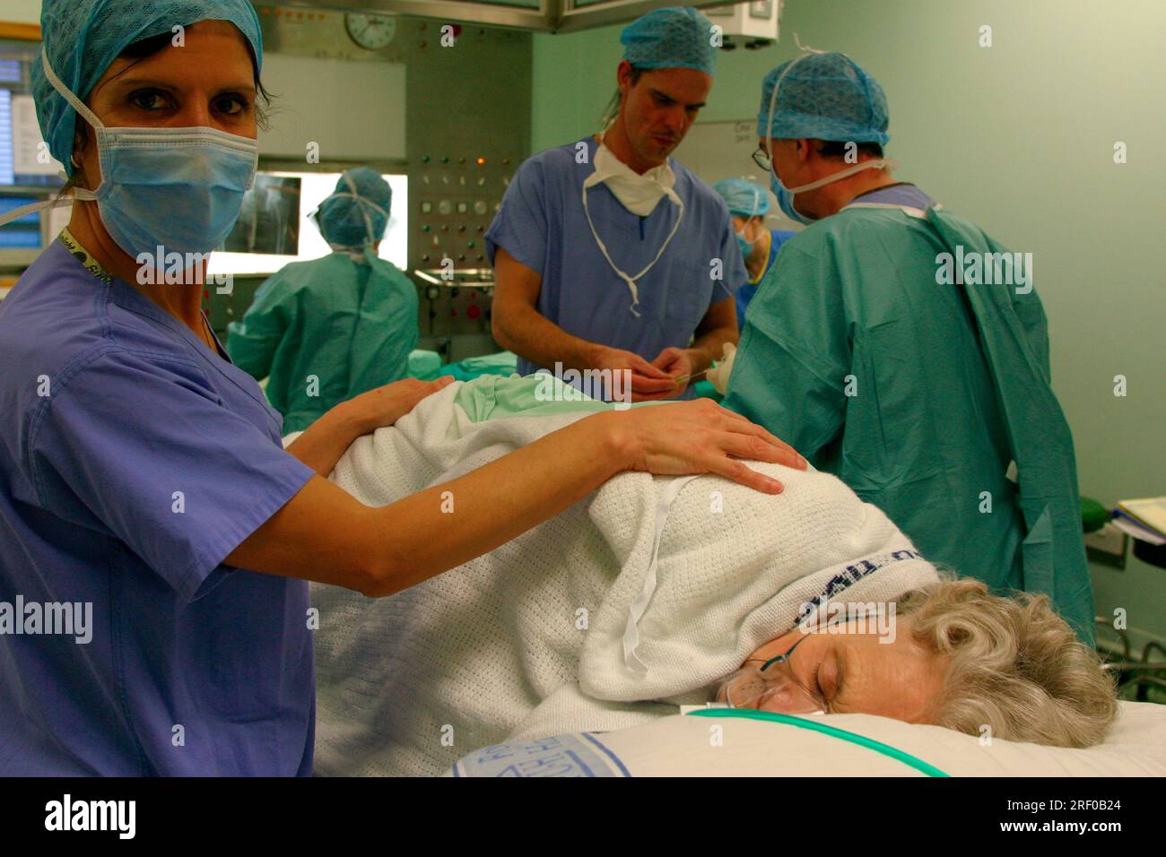 Medical team in a hospital operating room preparing a patient for ...